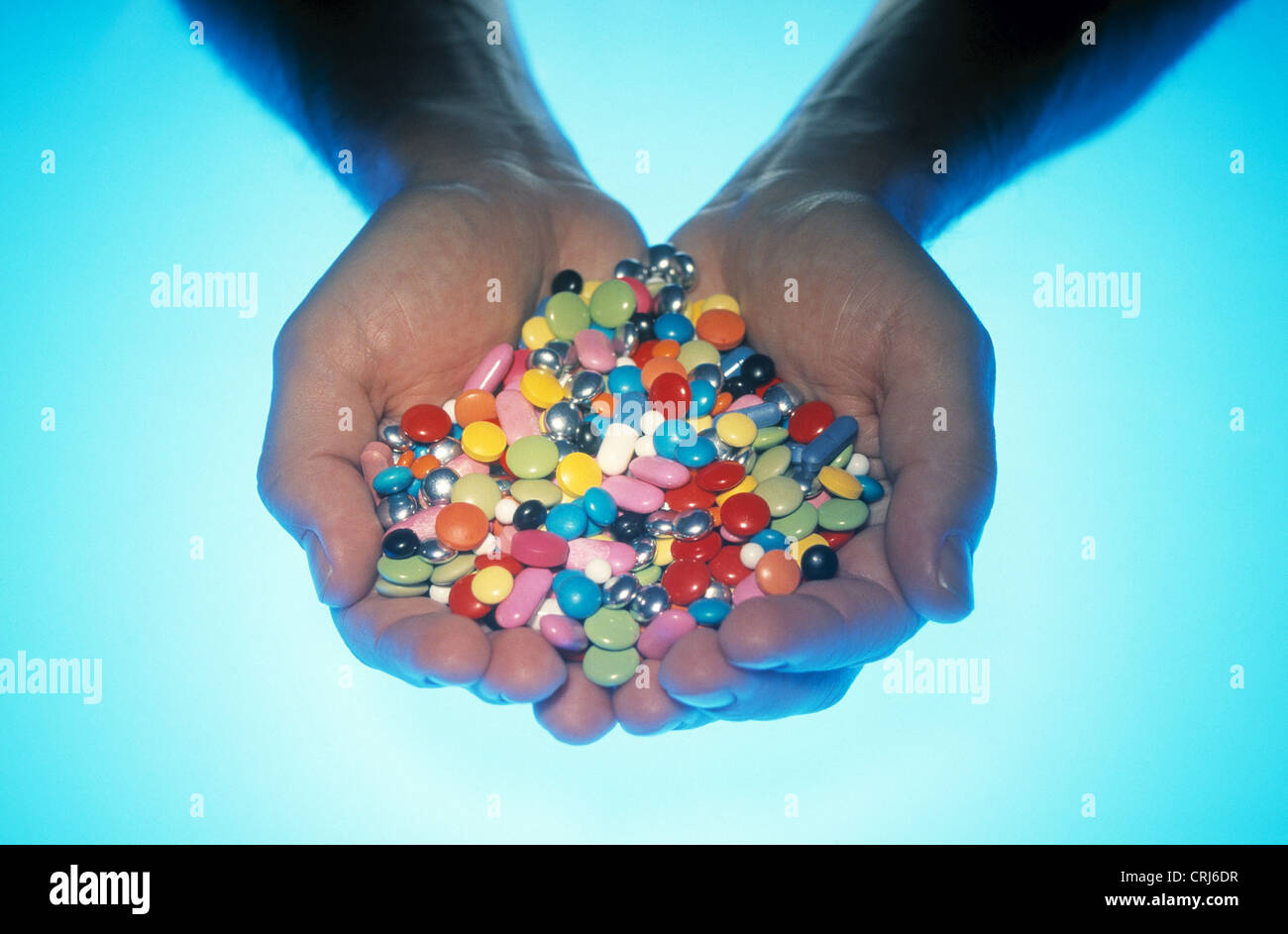 Two hands full of tablets Stock Photo - Alamy