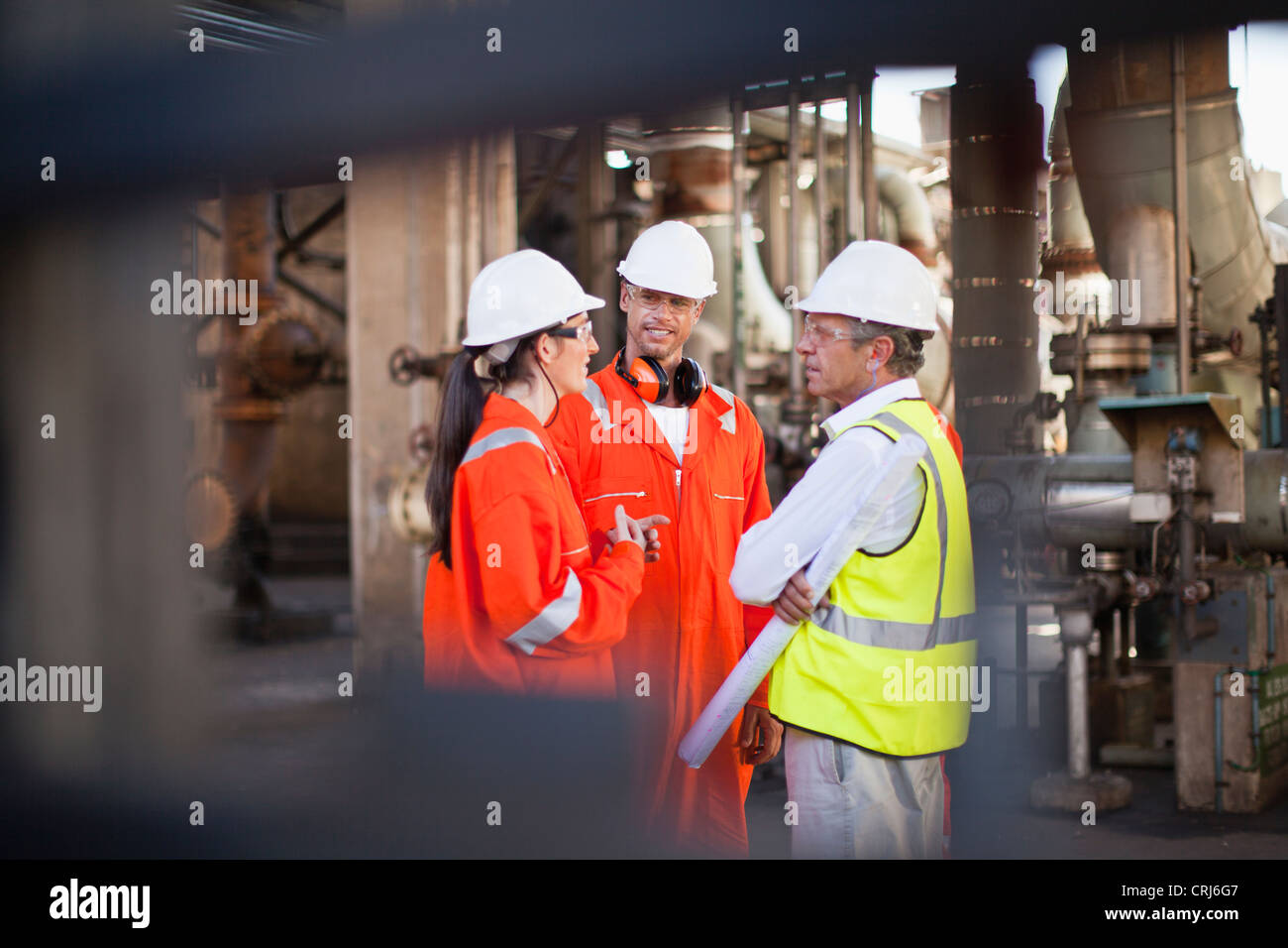 Workers talking at oil refinery Stock Photo - Alamy