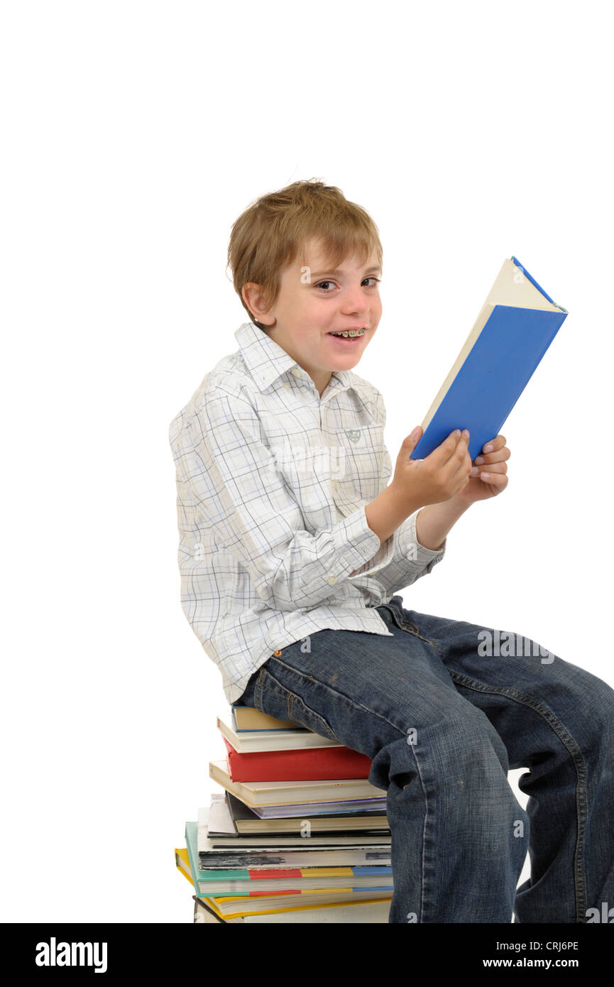 boy seated on a stack of books , reading. isolated on white Stock Photo ...