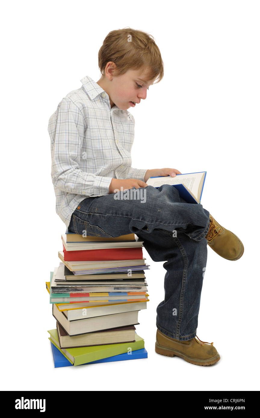 boy seated on a stack of books , reading. isolated on white Stock Photo ...