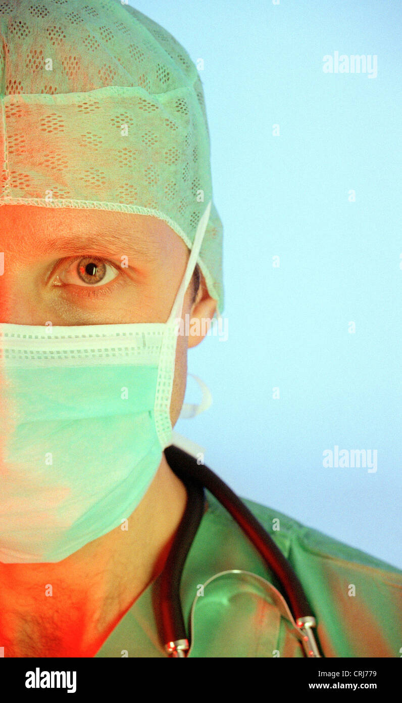 Doctor with scrubs, cap, surgical mask and a stethoscope Stock Photo ...