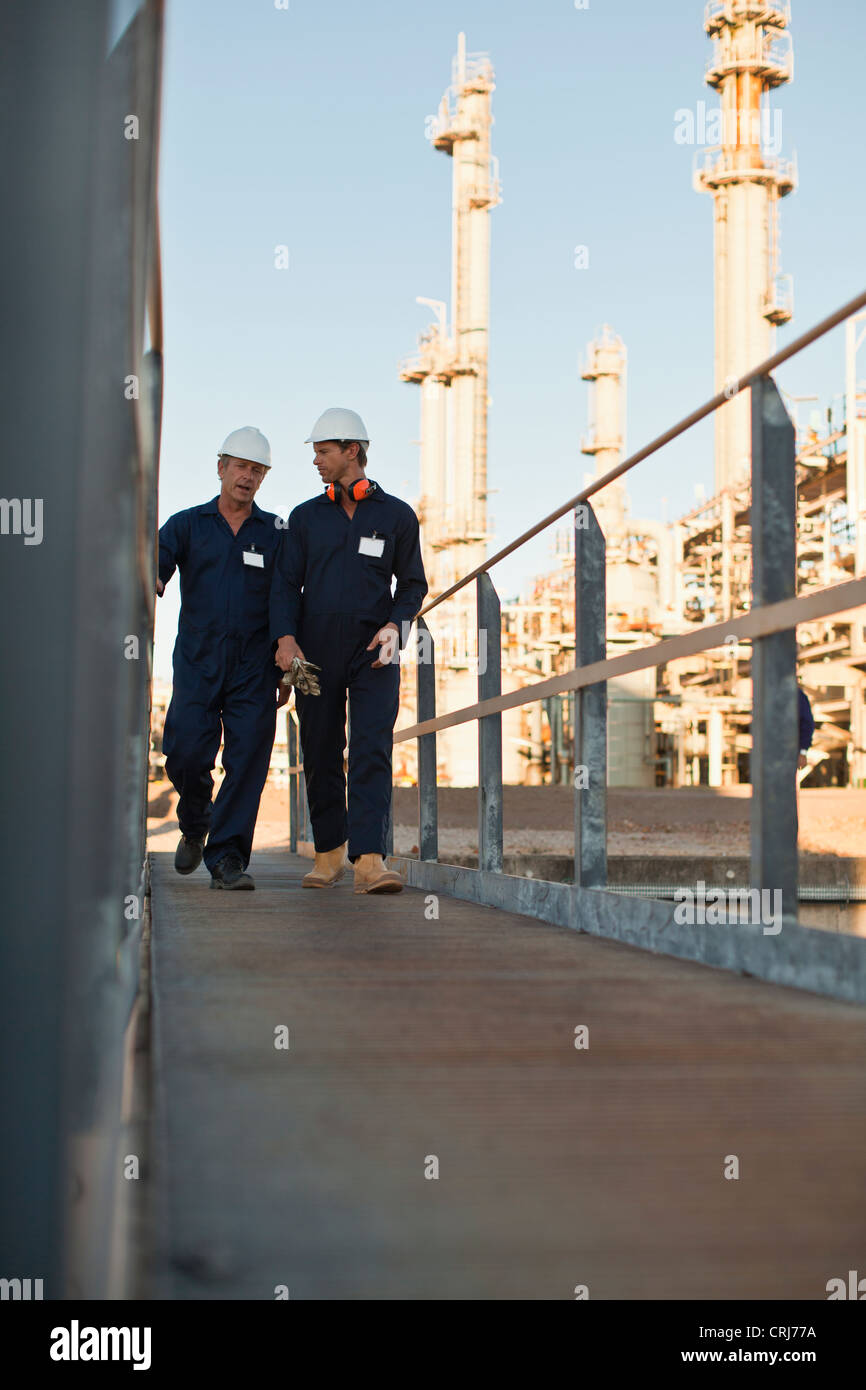 Workers walking at oil refinery Stock Photo - Alamy