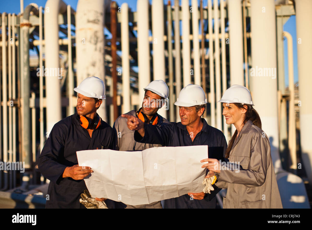 Workers with blueprints at oil refinery Stock Photo - Alamy