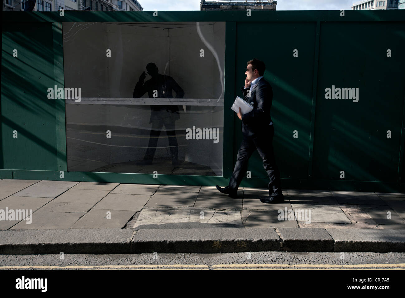 city of london man walks past statue of trader Stock Photo - Alamy