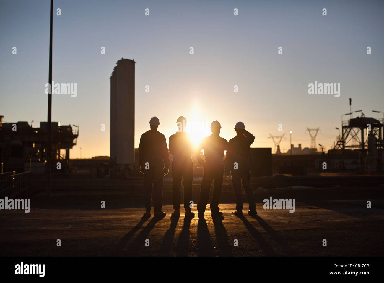 Silhouette of workers at oil refinery Stock Photo - Alamy