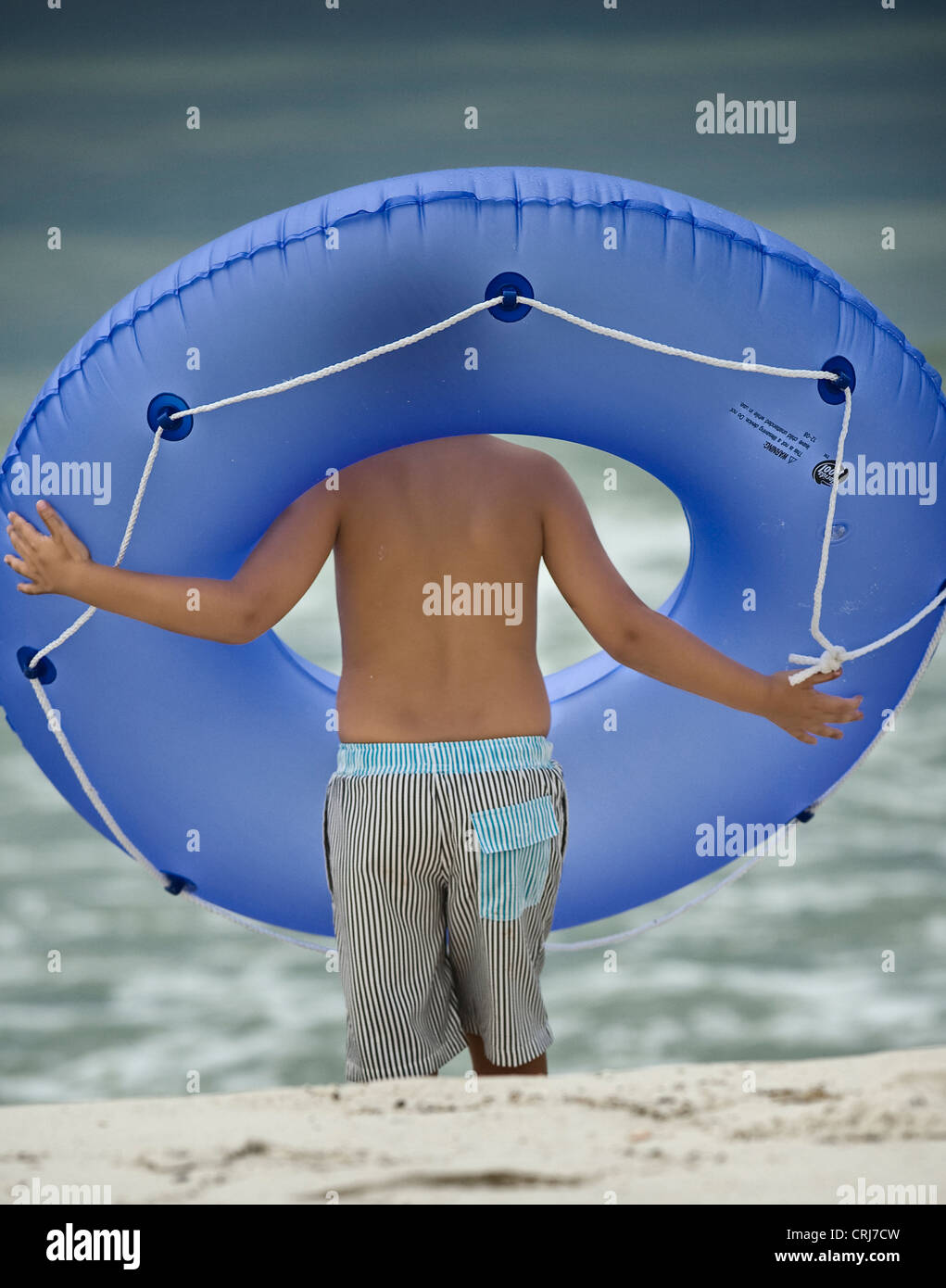 Boy in water with float Stock Photo - Alamy