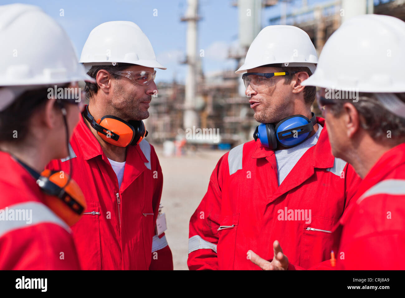 Workers talking at oil refinery Stock Photo - Alamy