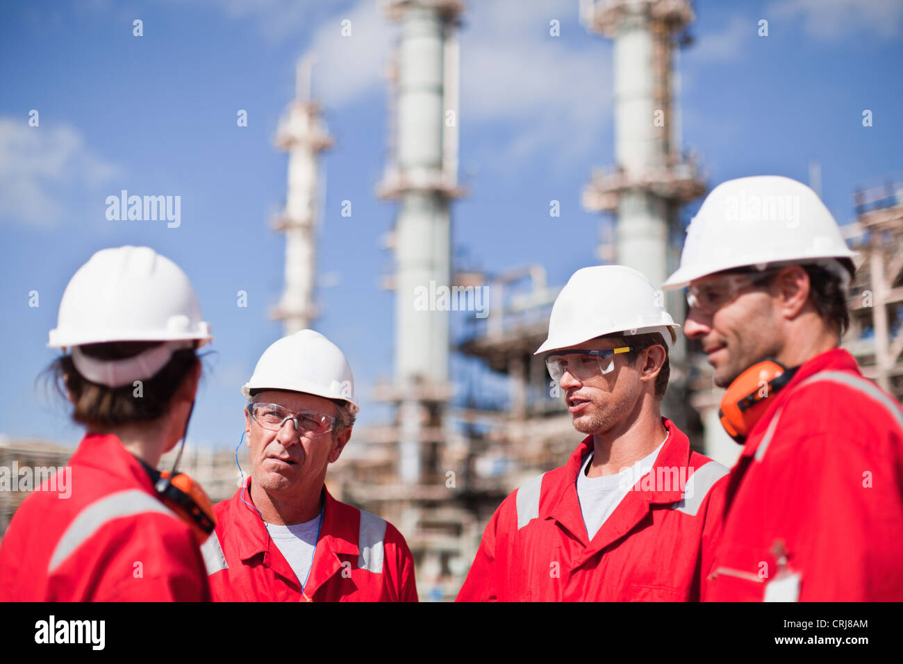 Workers talking at oil refinery Stock Photo - Alamy