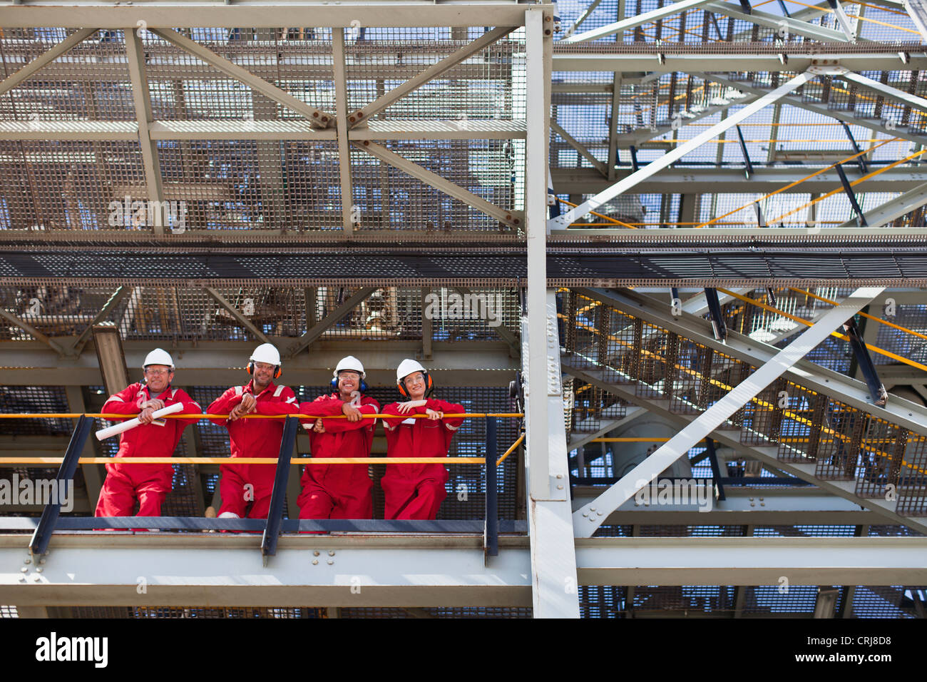Workers standing on ledge together Stock Photo - Alamy