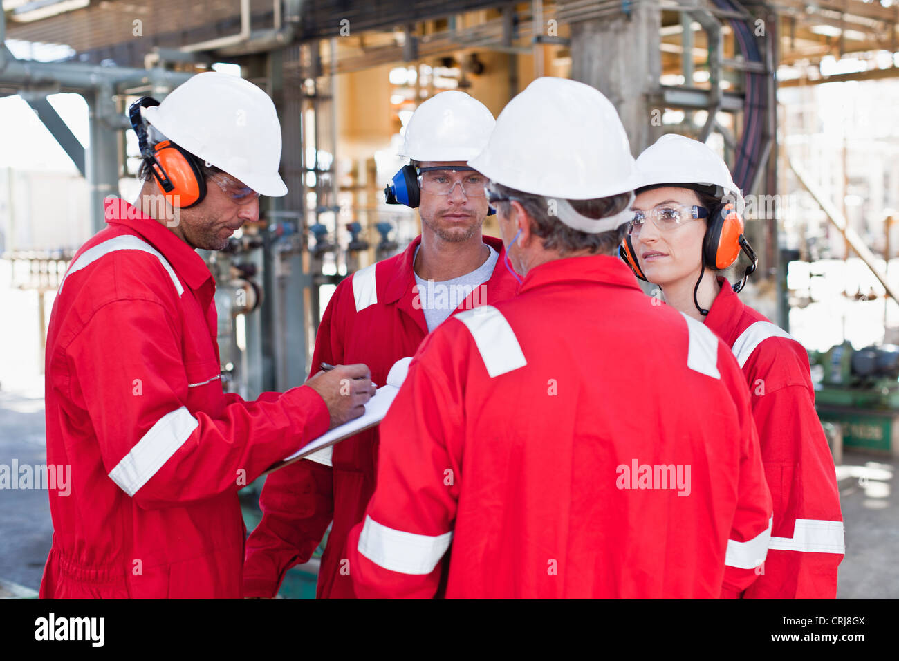 Workers talking at oil refinery Stock Photo - Alamy