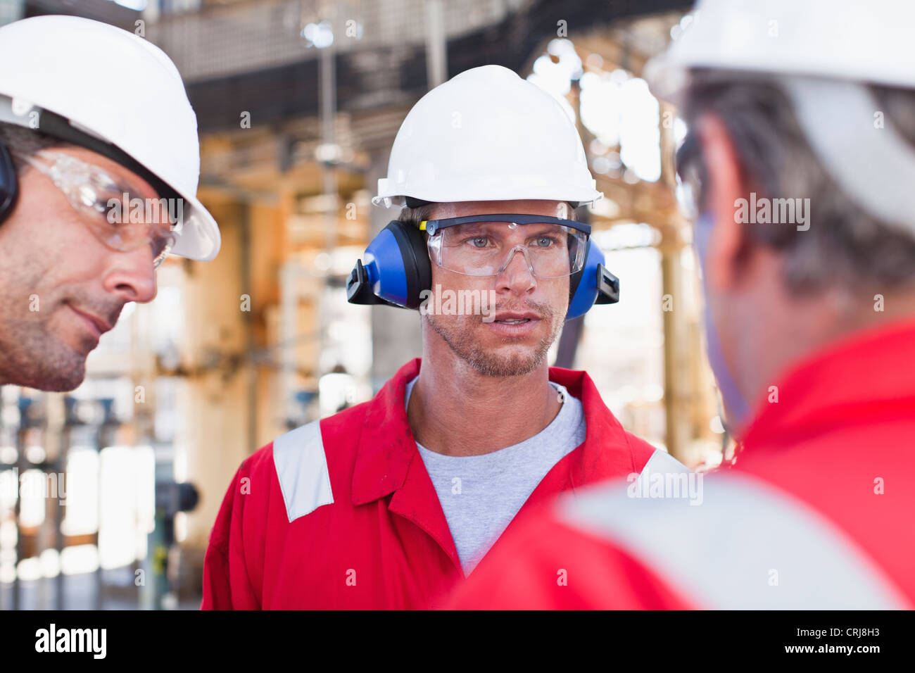 Workers talking at oil refinery Stock Photo - Alamy