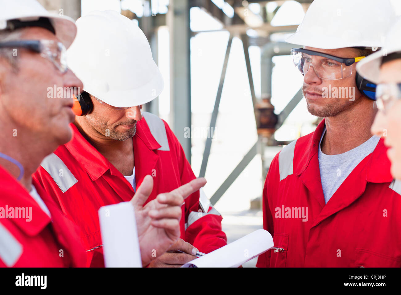 Workers talking at oil refinery Stock Photo - Alamy