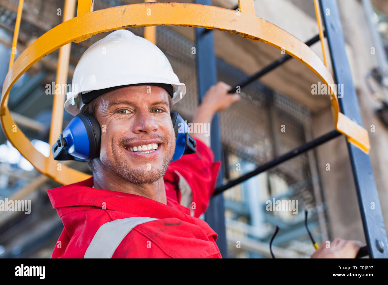Worker climbing ladder at oil refinery Stock Photo - Alamy