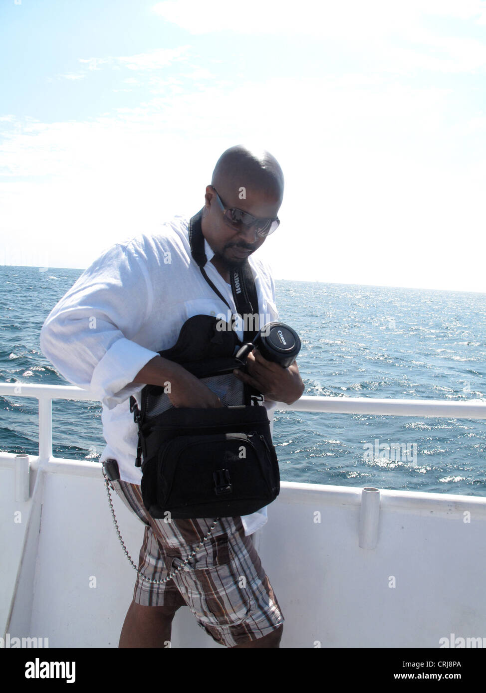 Man on boat with camera Stock Photo - Alamy