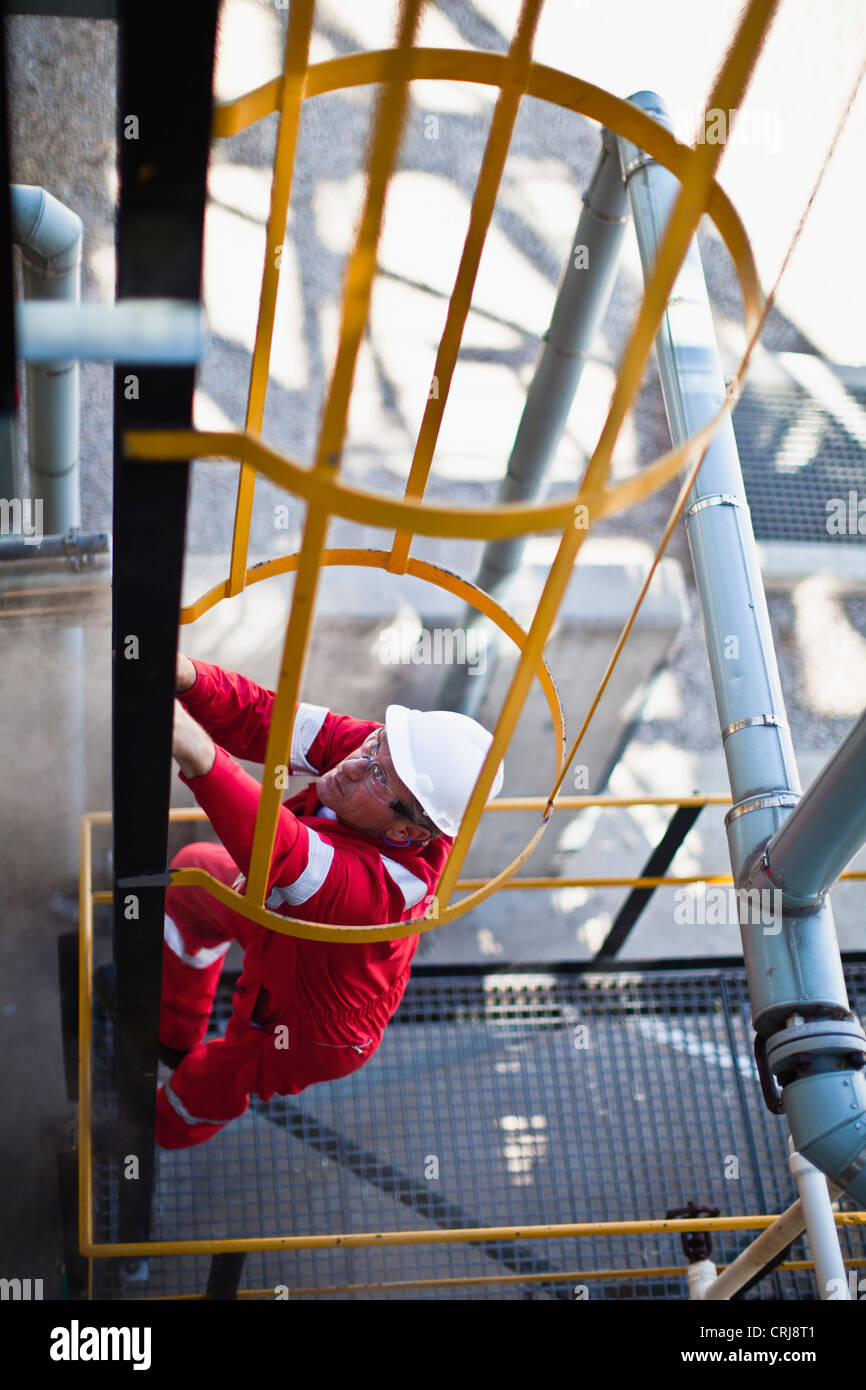 Worker climbing ladder at oil refinery Stock Photo - Alamy