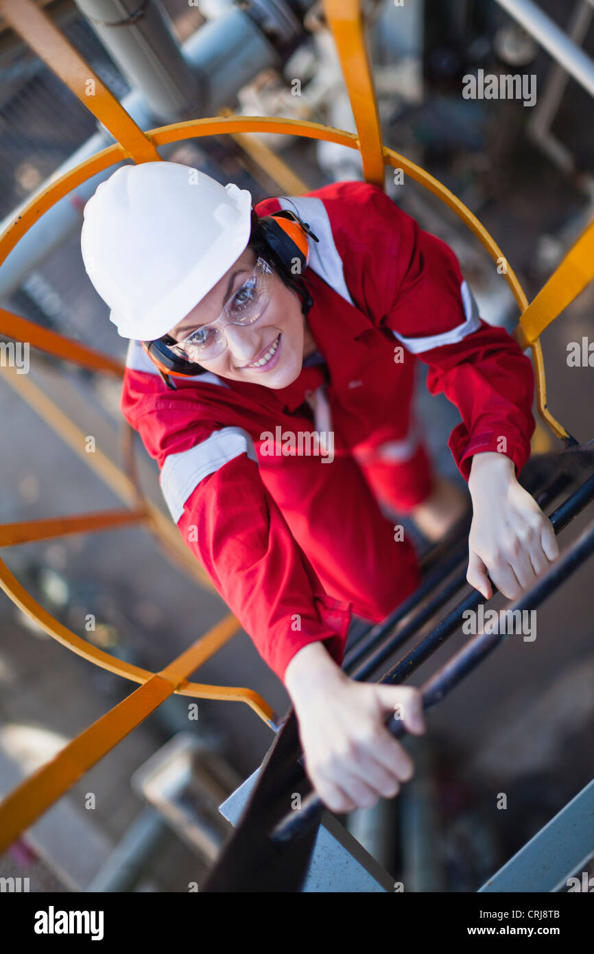 Worker climbing ladder at oil refinery Stock Photo - Alamy