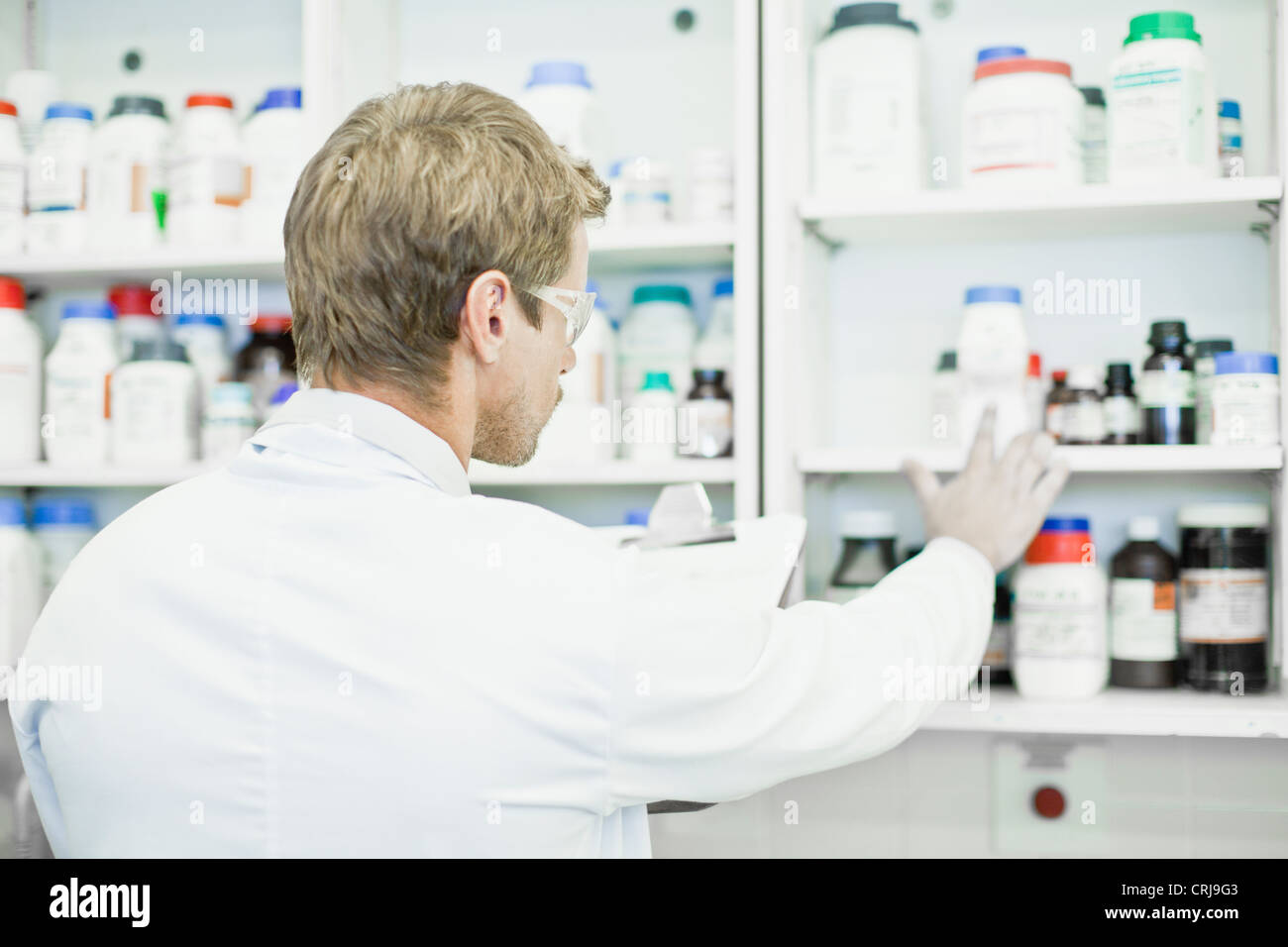Scientist examining jars in lab Stock Photo - Alamy