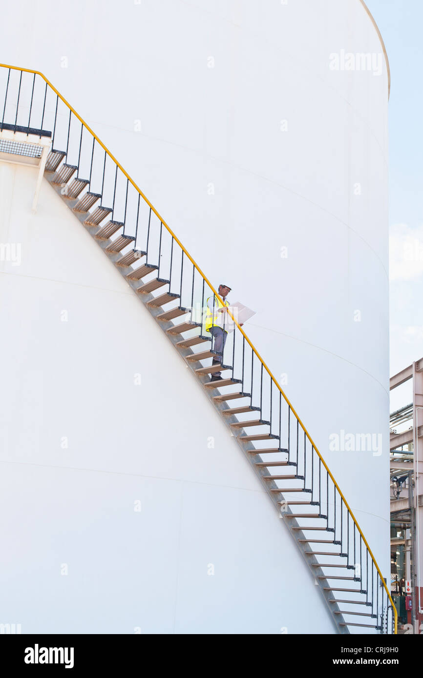 Worker climbing steps at chemical plant Stock Photo - Alamy