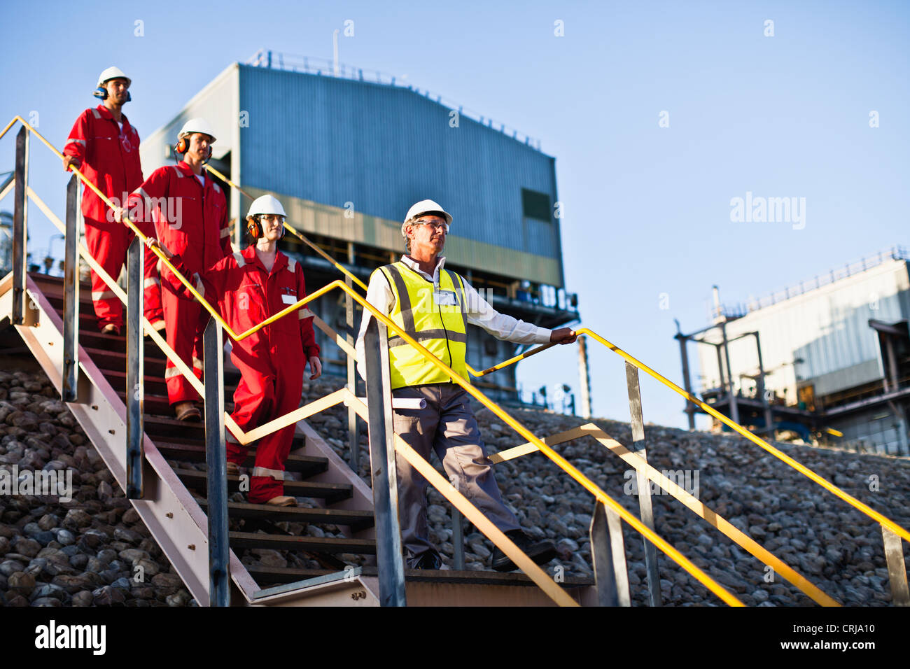 Workers on steps at chemical plant Stock Photo - Alamy