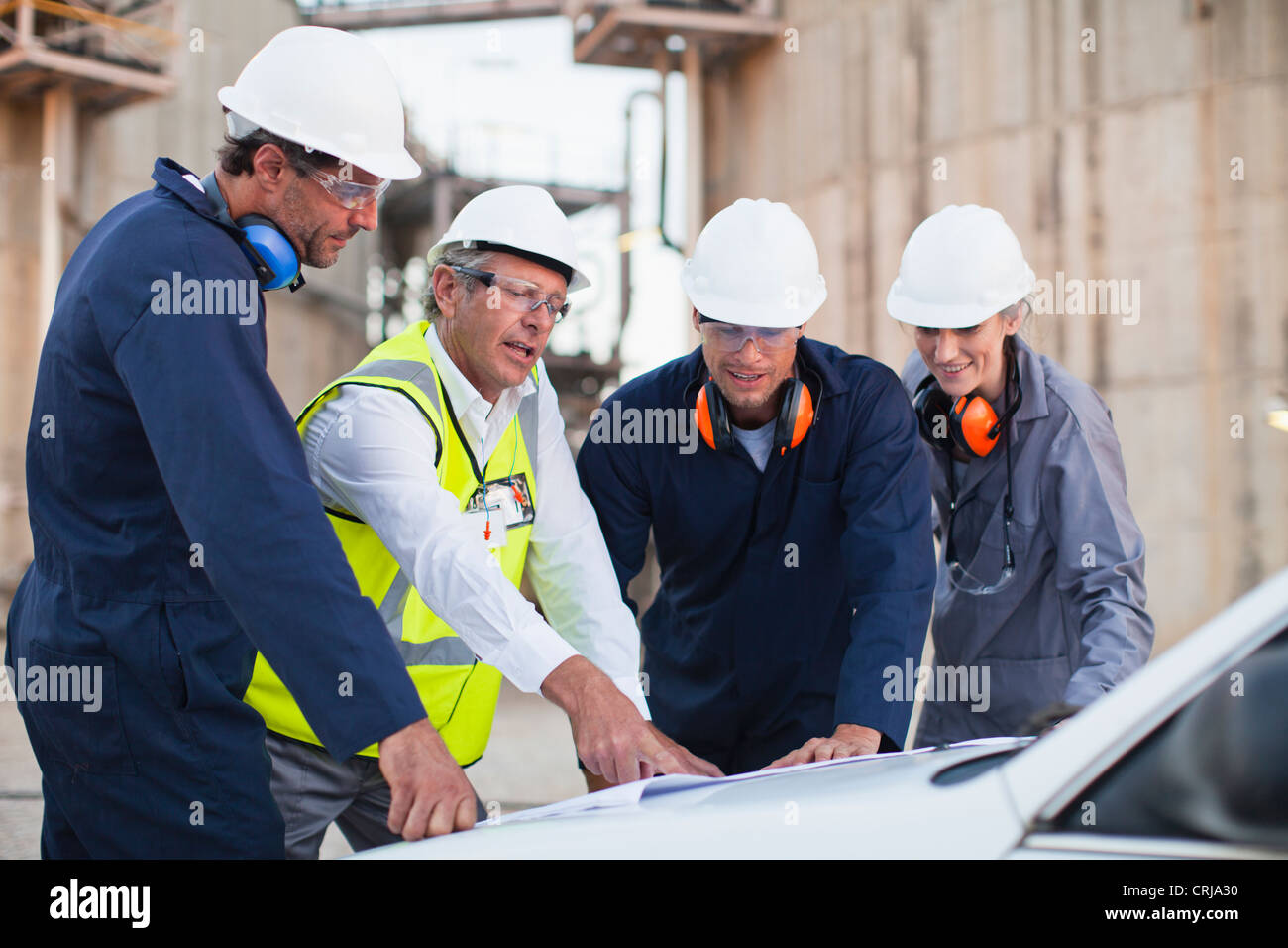 Workers reading blueprints at plant Stock Photo - Alamy