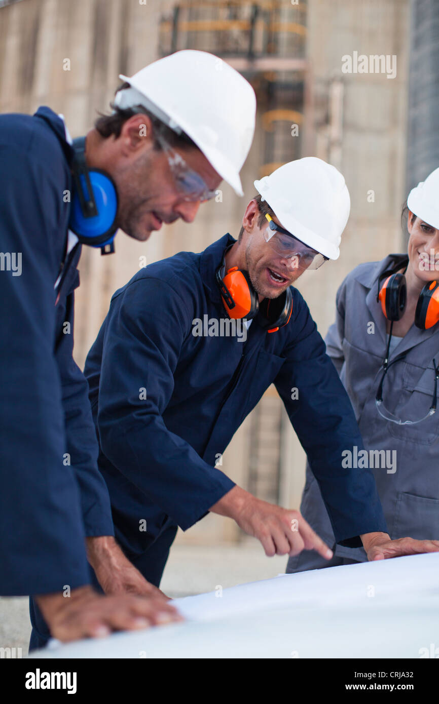 Workers reading blueprints at plant Stock Photo - Alamy