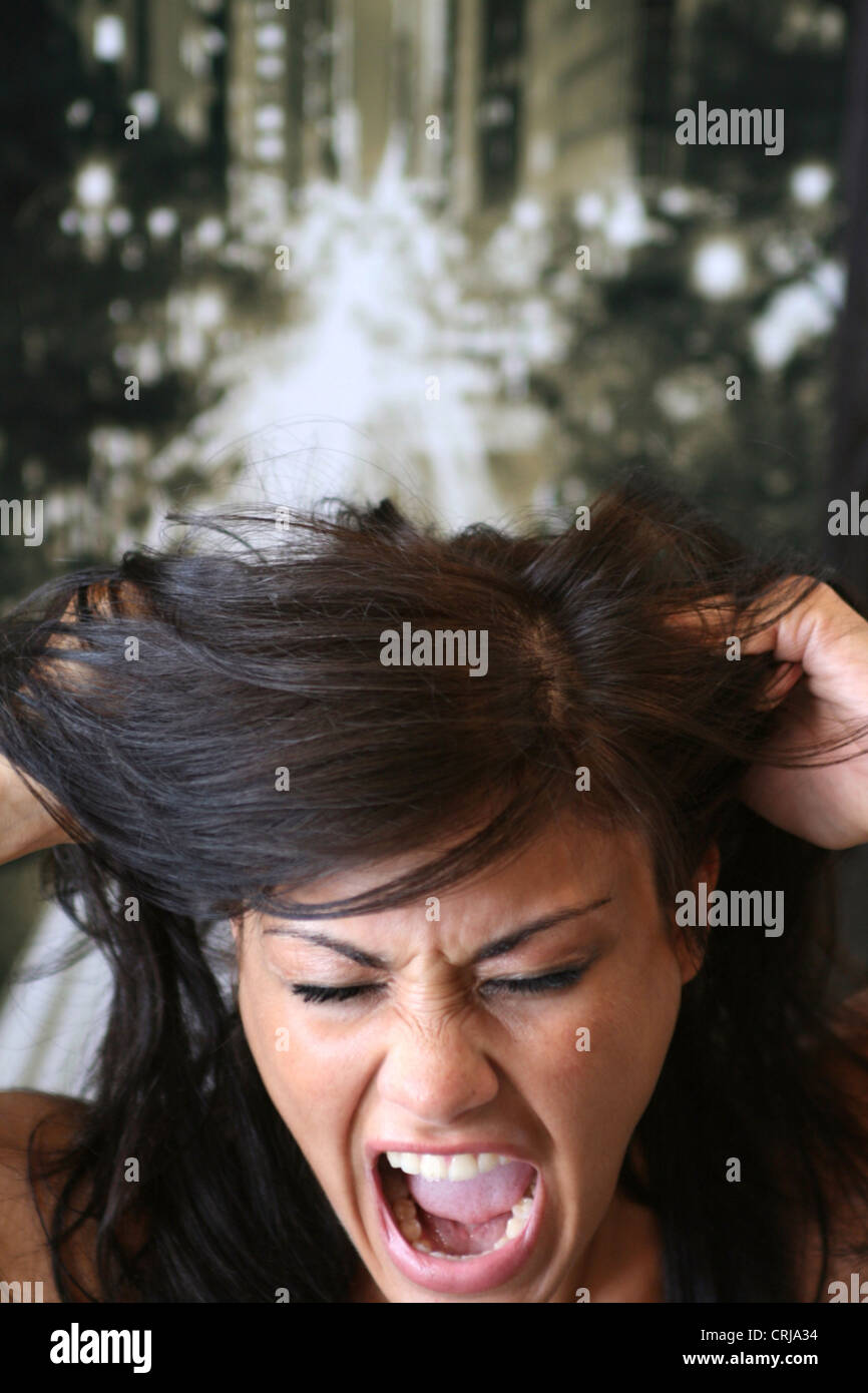 young woman screaming and tearing her long brown hair Stock Photo - Alamy