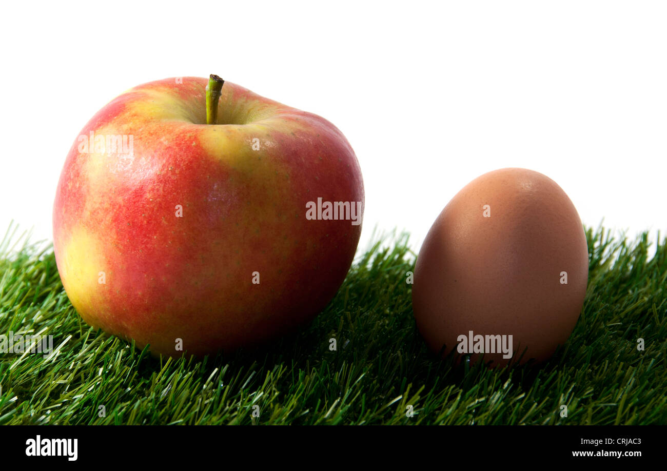 apple and egg on green grass with white background Stock Photo - Alamy