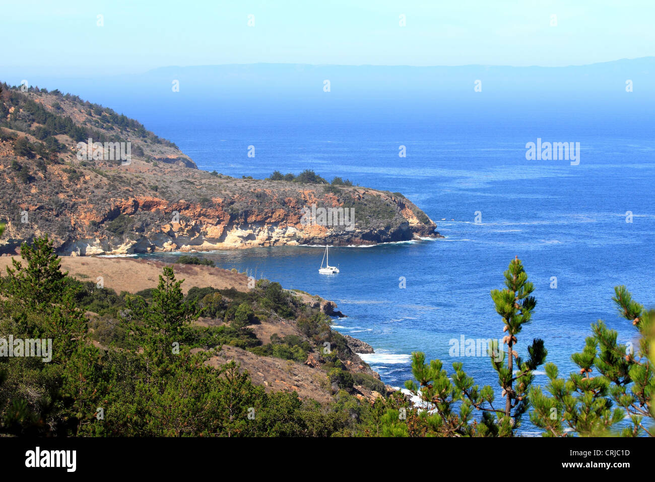 A sailboat in a bay at Santa Cruz Island with a blue ocean Stock Photo ...