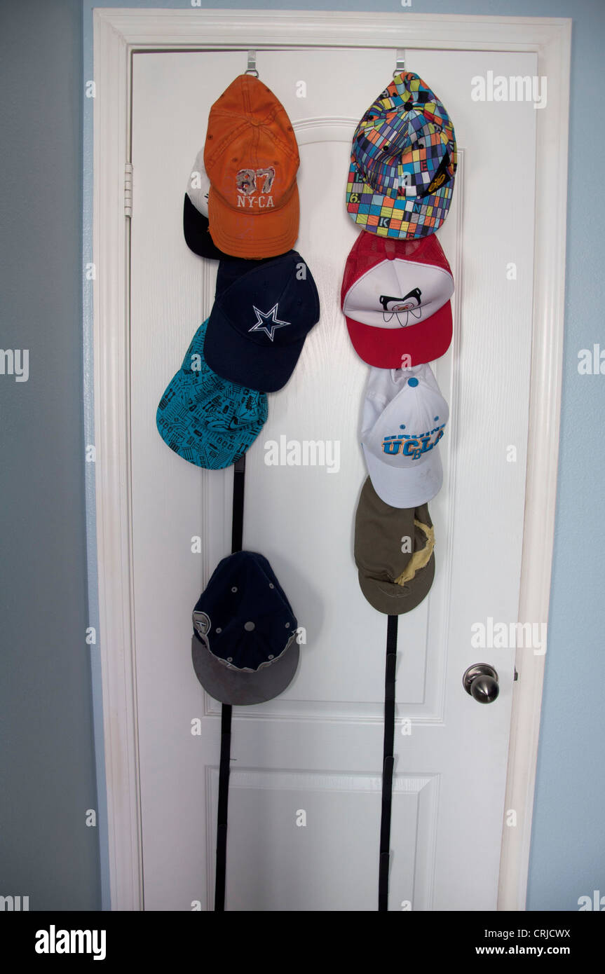 Hat collection hanging on a door Stock Photo - Alamy