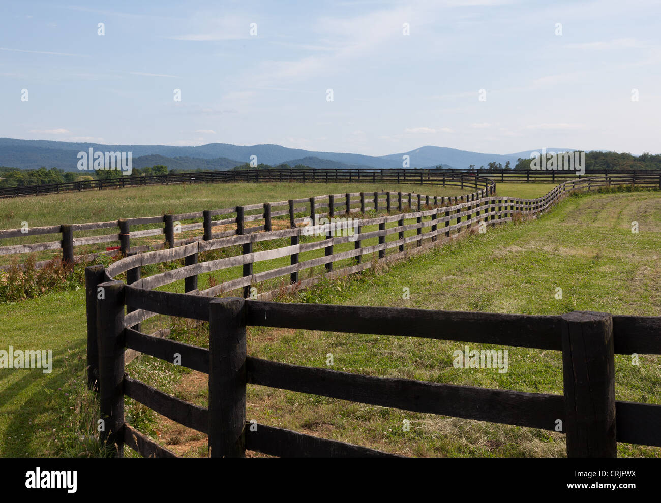 Green pasture land with wooden fences and hills in background Stock ...