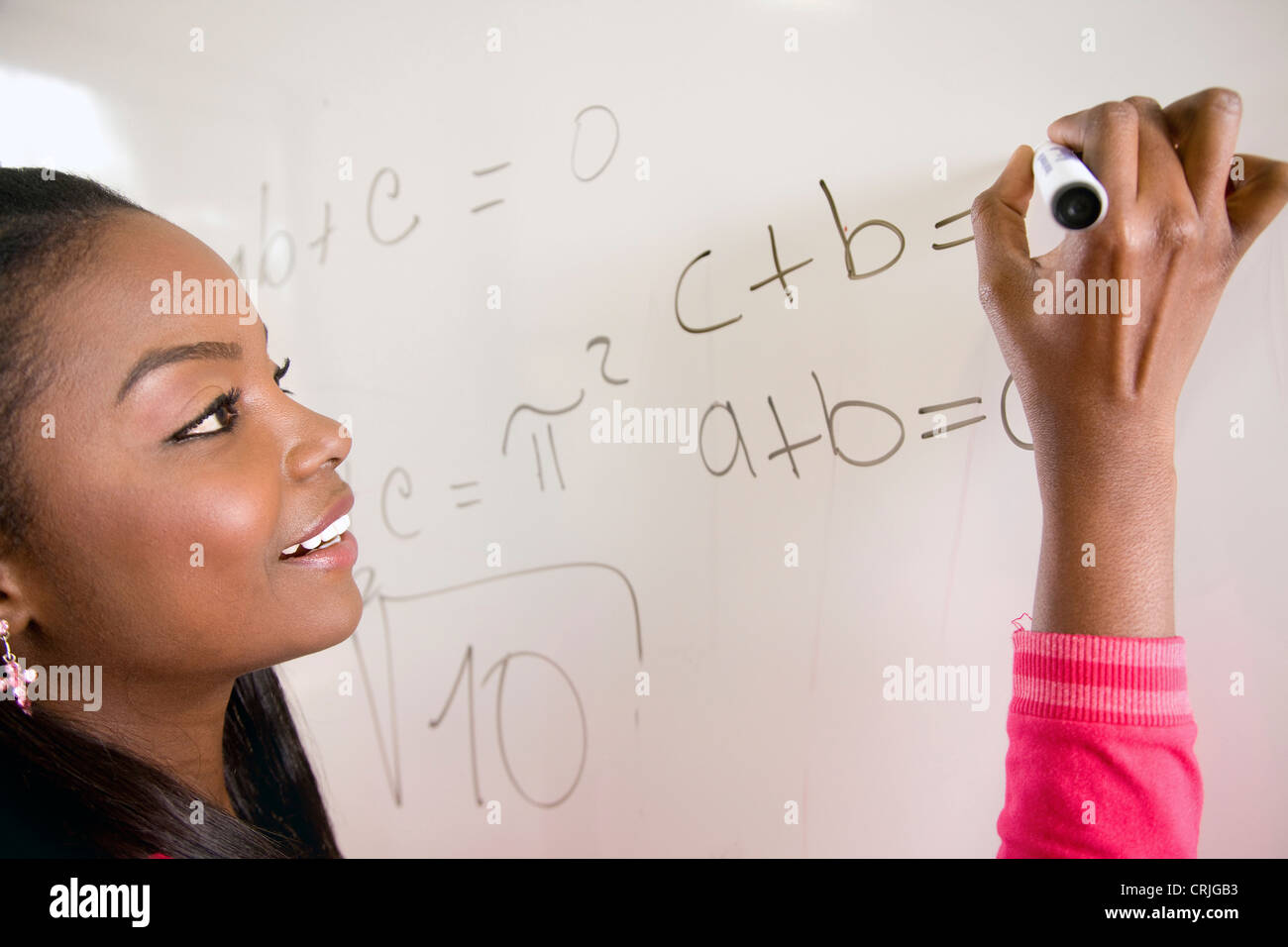 female math student writing equations on the wall panel Stock Photo - Alamy