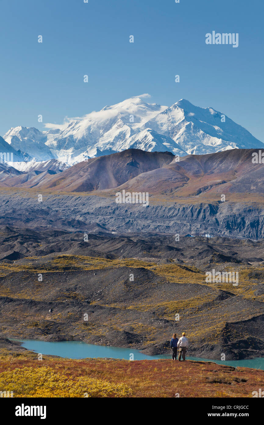 Hikers enjoy a sunny fall day of Mt. McKinley from the tundra next to ...