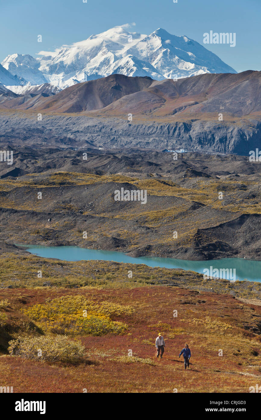 Hikers enjoy a sunny fall day of Mt. McKinley from the tundra next to ...