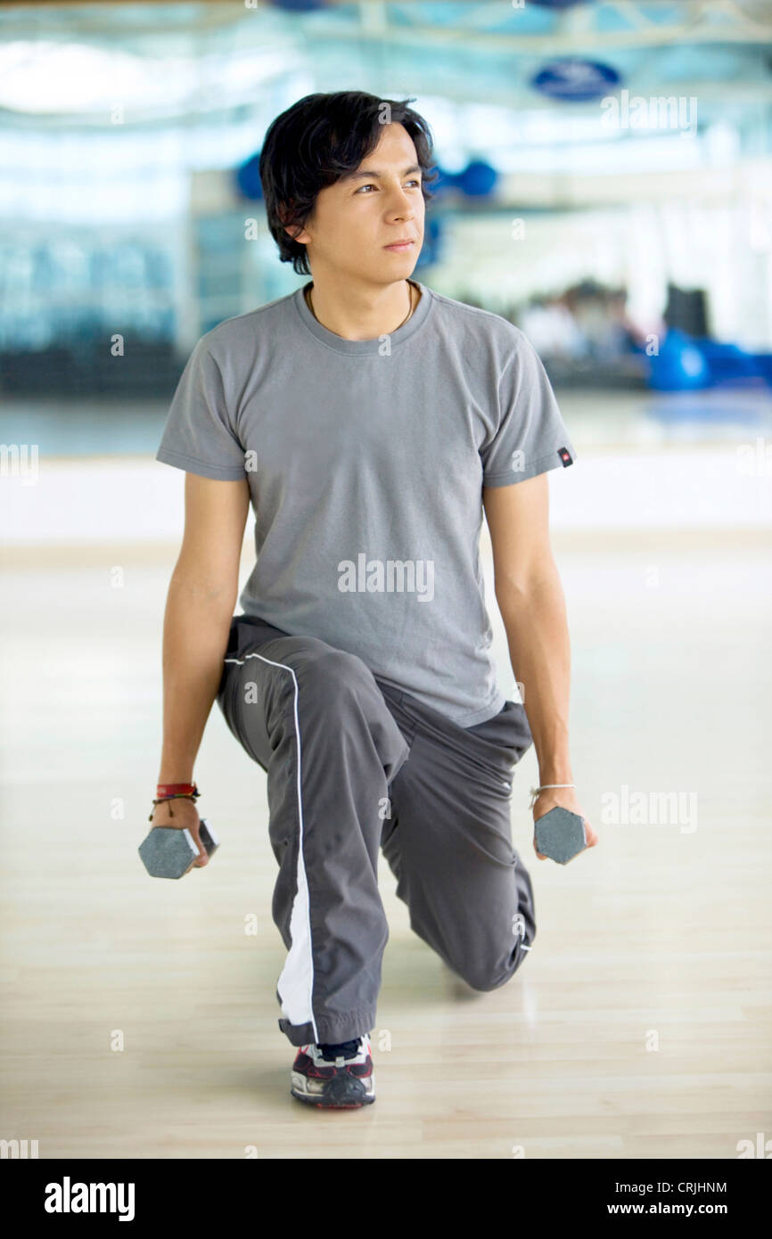 Gym man bending with freeweights Stock Photo - Alamy