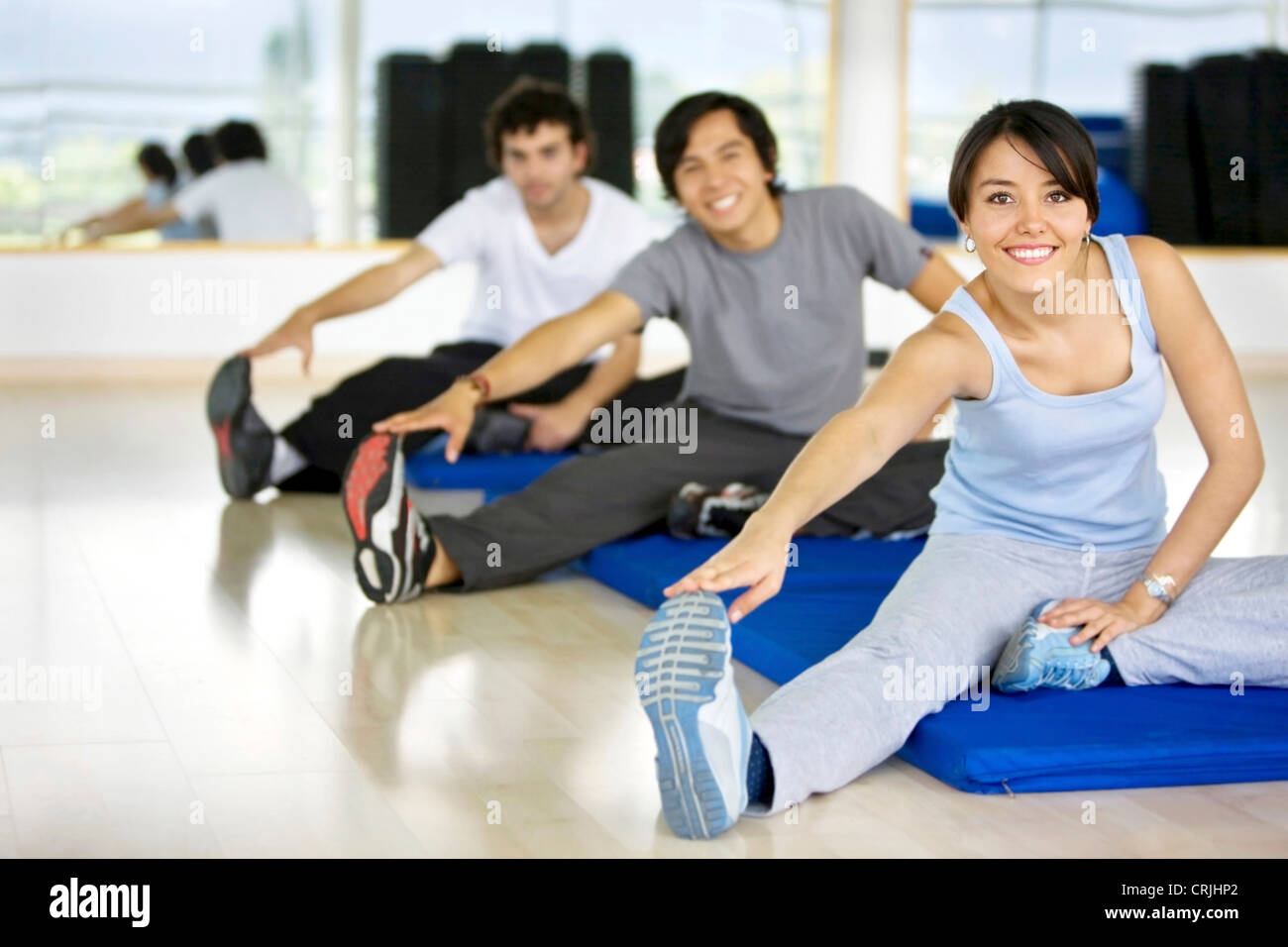 People doing stretching exercises on the floor at the gym Stock Photo ...