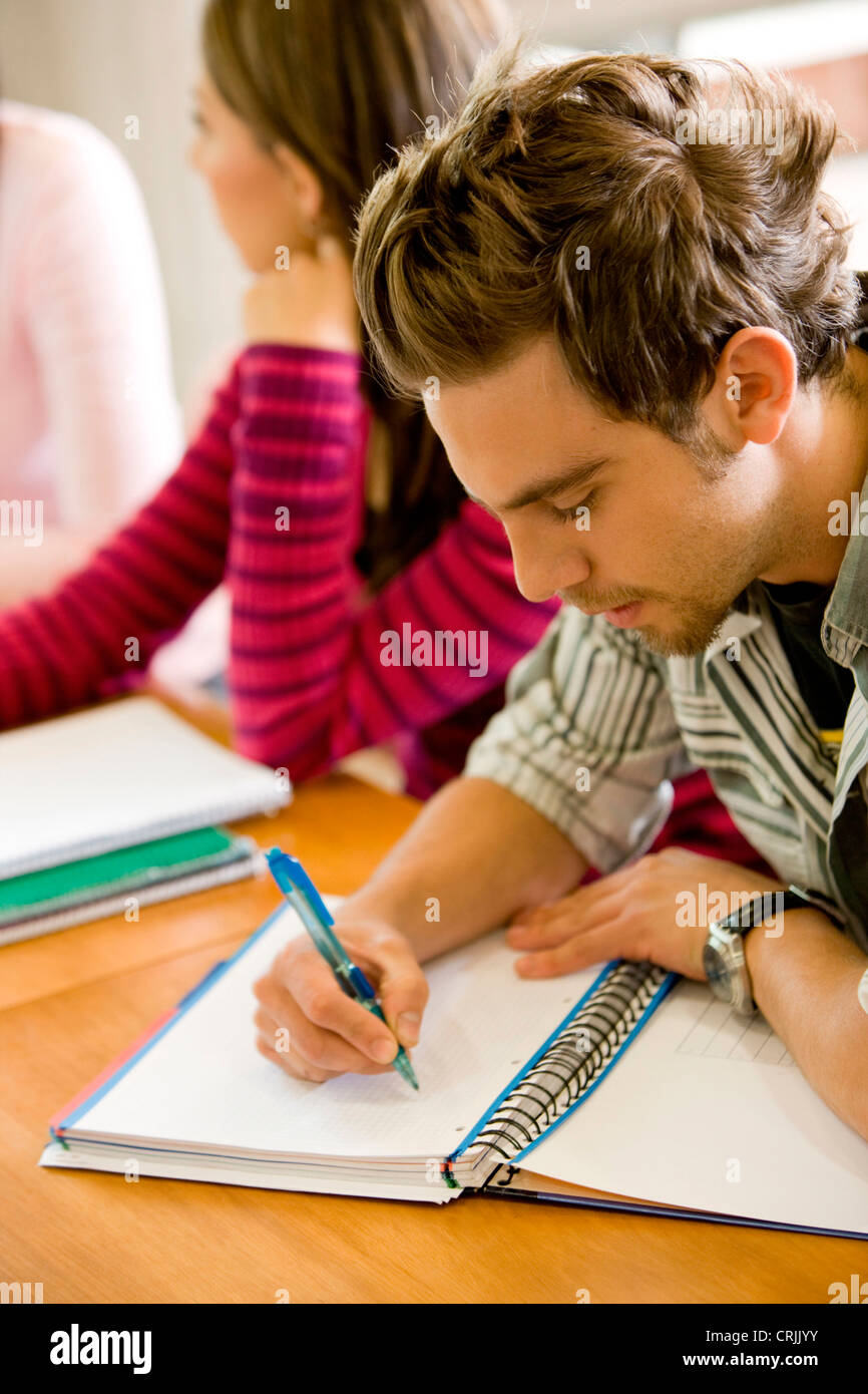 young man studying in the classroom writting on his notebook Stock ...