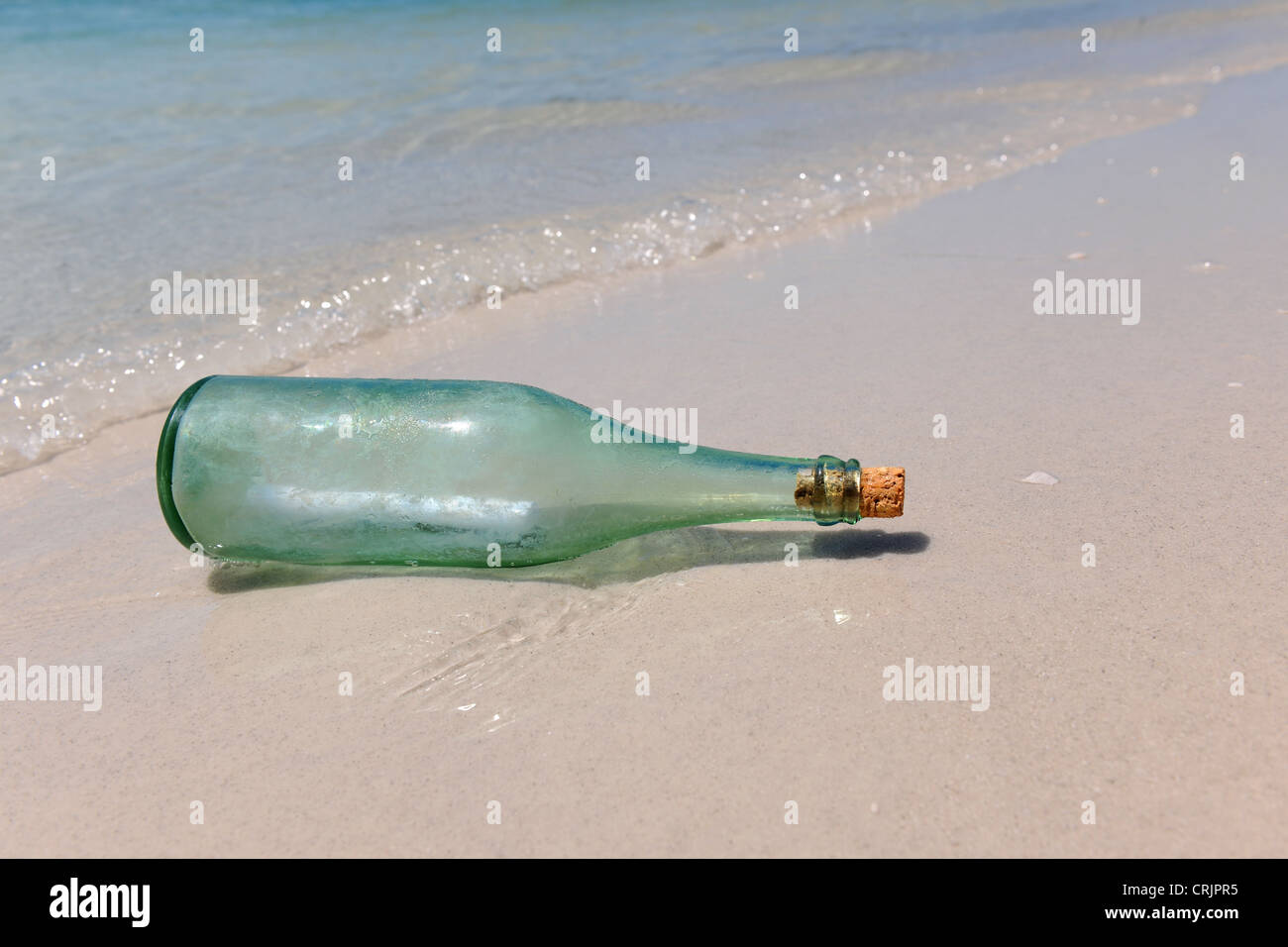 Message in a bottle resting on shore of beach Stock Photo - Alamy