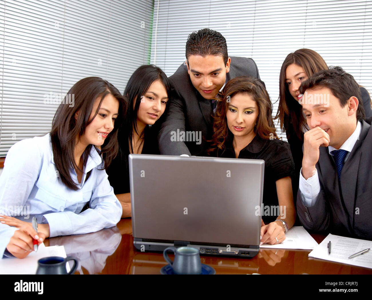 business team during a meeting in an office looking at a laptop ...