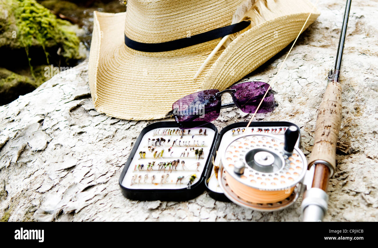 Fly fishing gear including fly box laying on a rock Stock Photo - Alamy