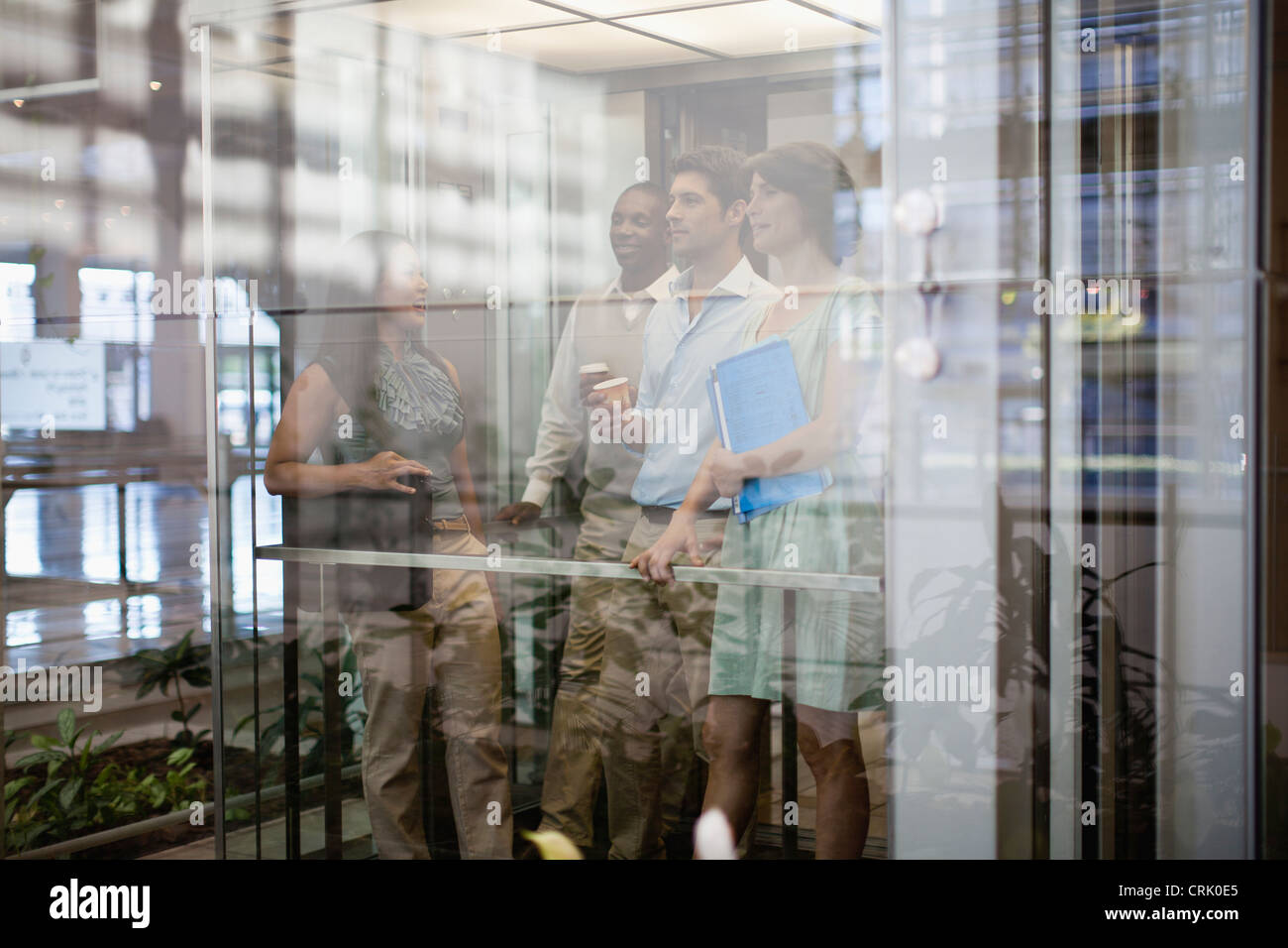 Business people riding glass elevator Stock Photo - Alamy