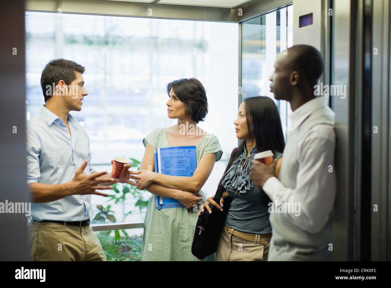 Business people riding glass elevator Stock Photo - Alamy