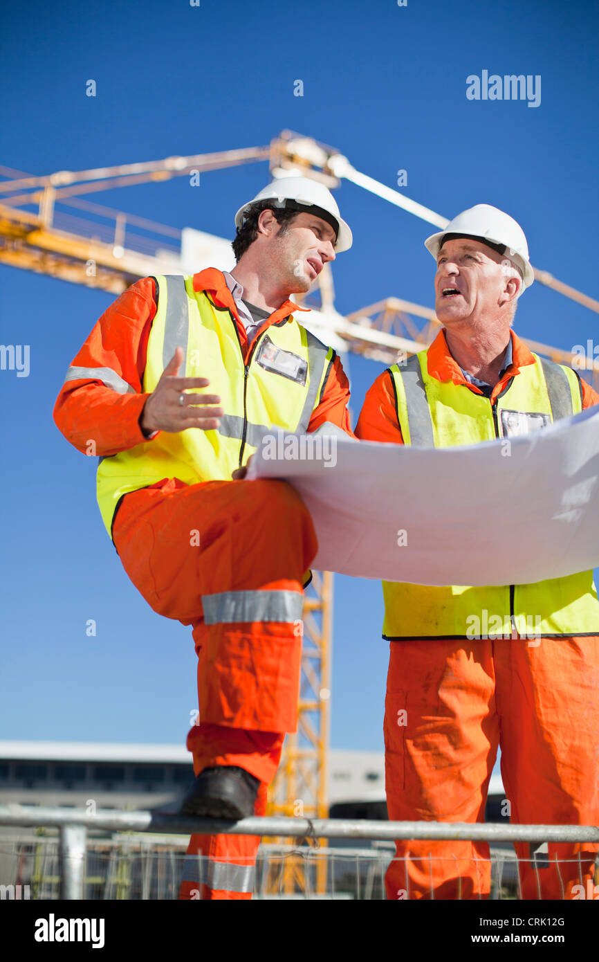 Construction workers reading blueprint on hi-res stock photography and ...