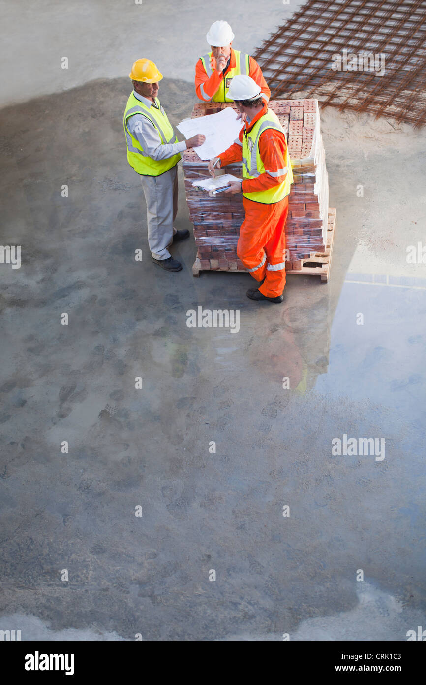 Workers reading blueprints on site Stock Photo - Alamy