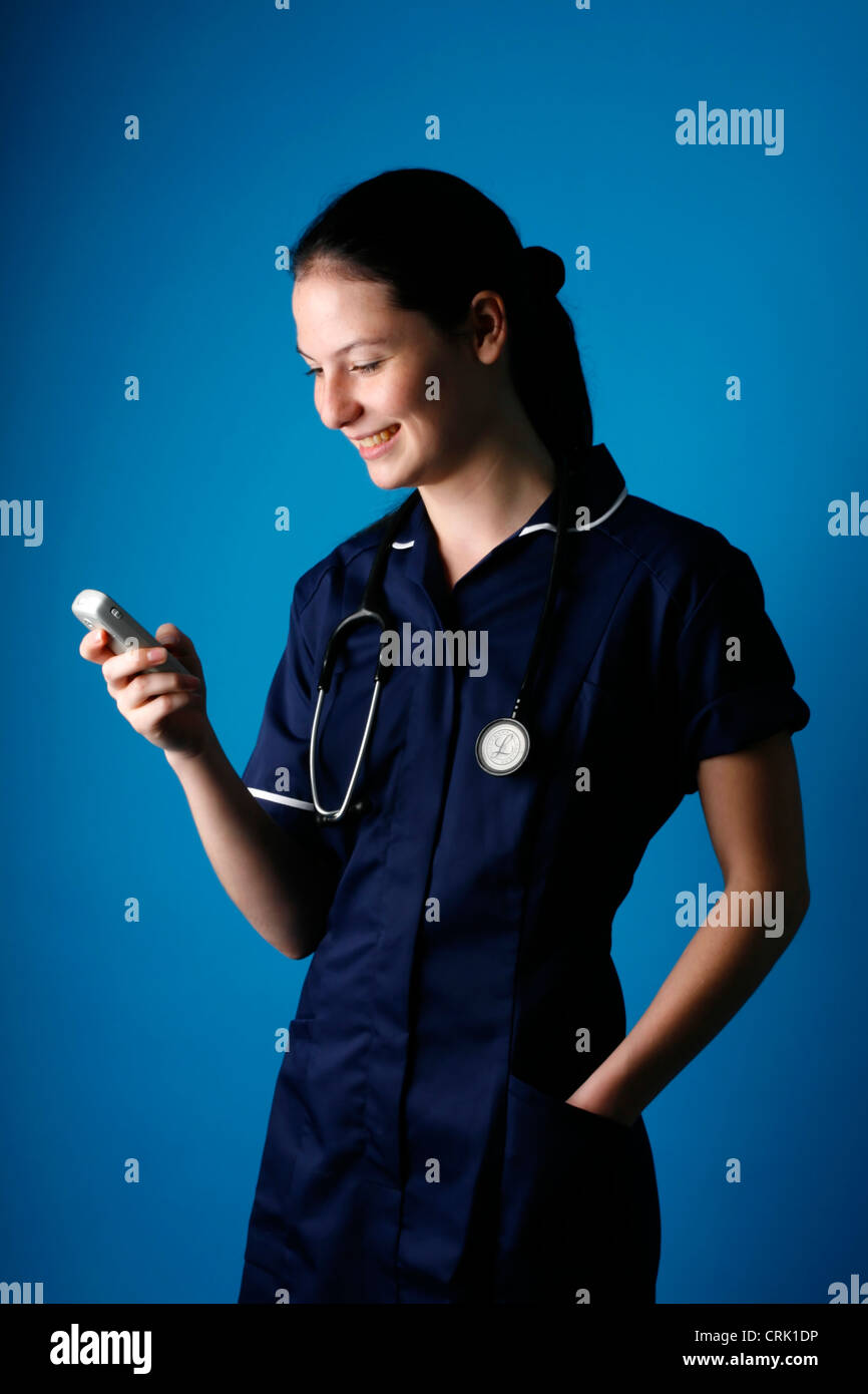 A young nurse using a mobile telephone Stock Photo - Alamy