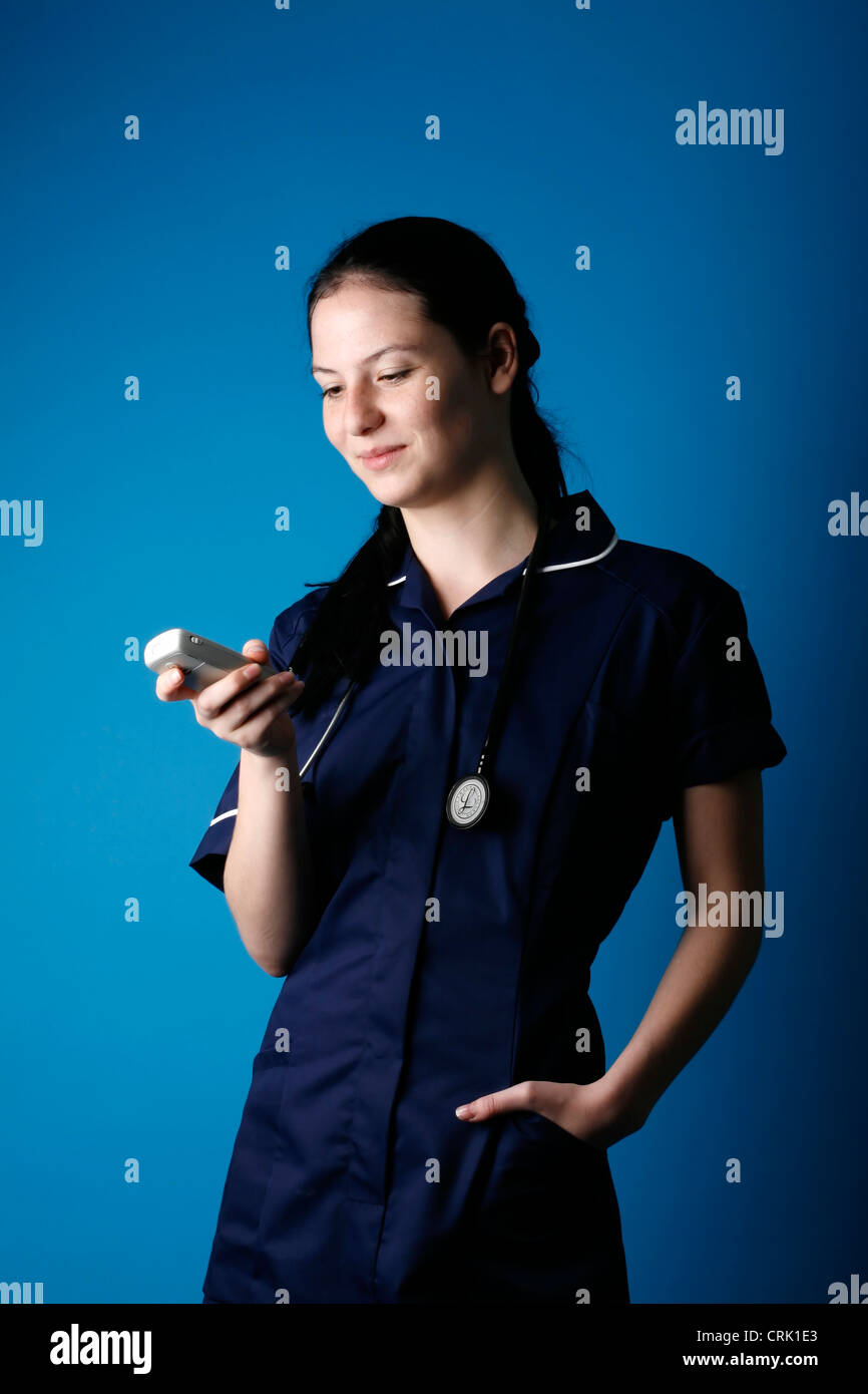 A young nurse using a mobile telephone Stock Photo - Alamy