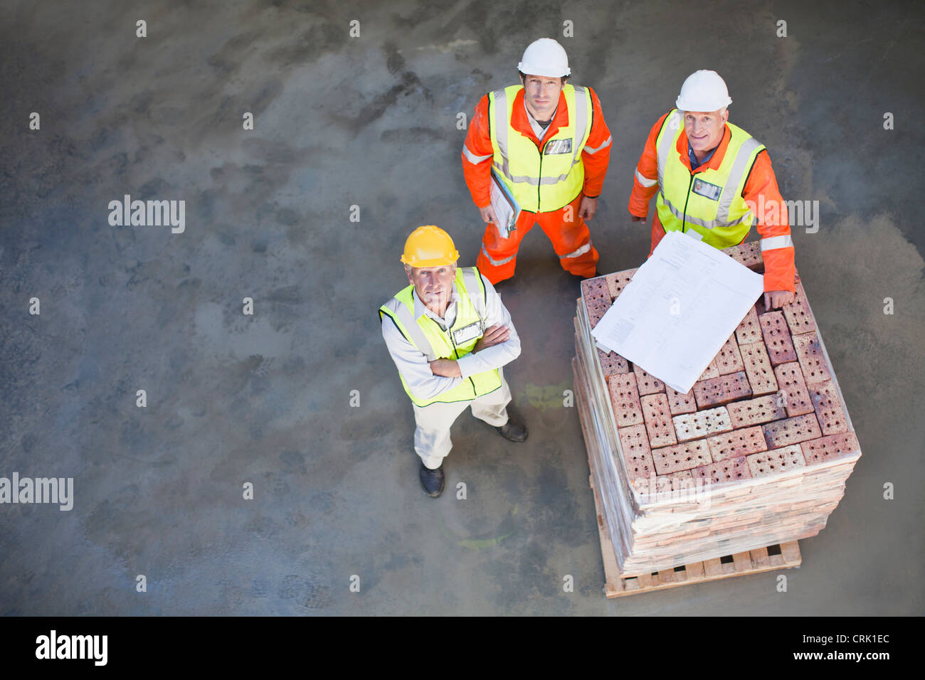 Workers reading blueprints on site Stock Photo - Alamy