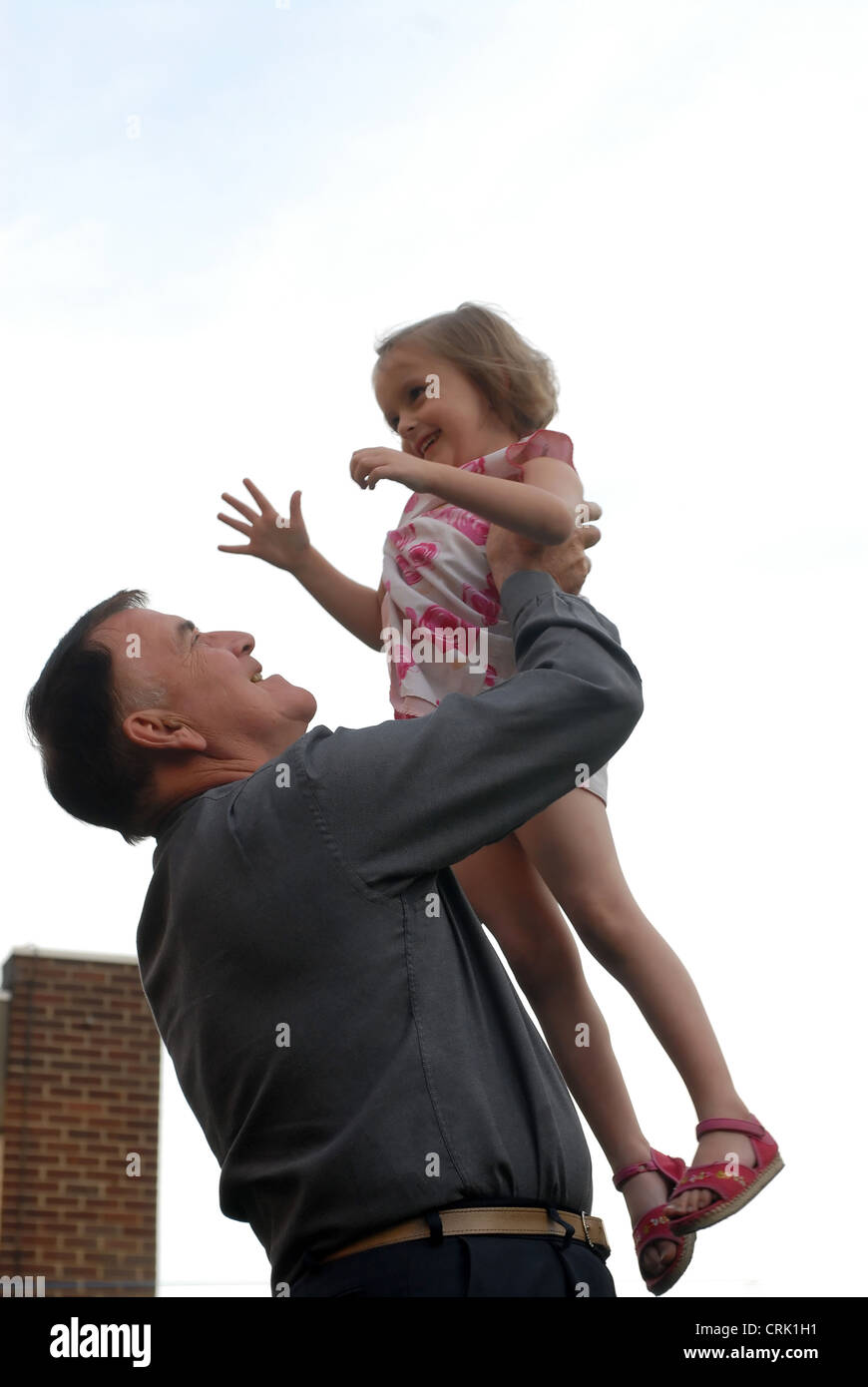 An elderly man throws a young child above his head Stock Photo - Alamy