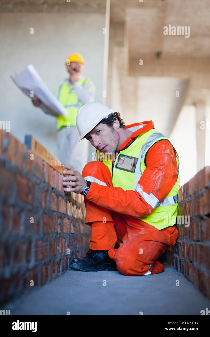 Worker laying brick at construction site Stock Photo - Alamy