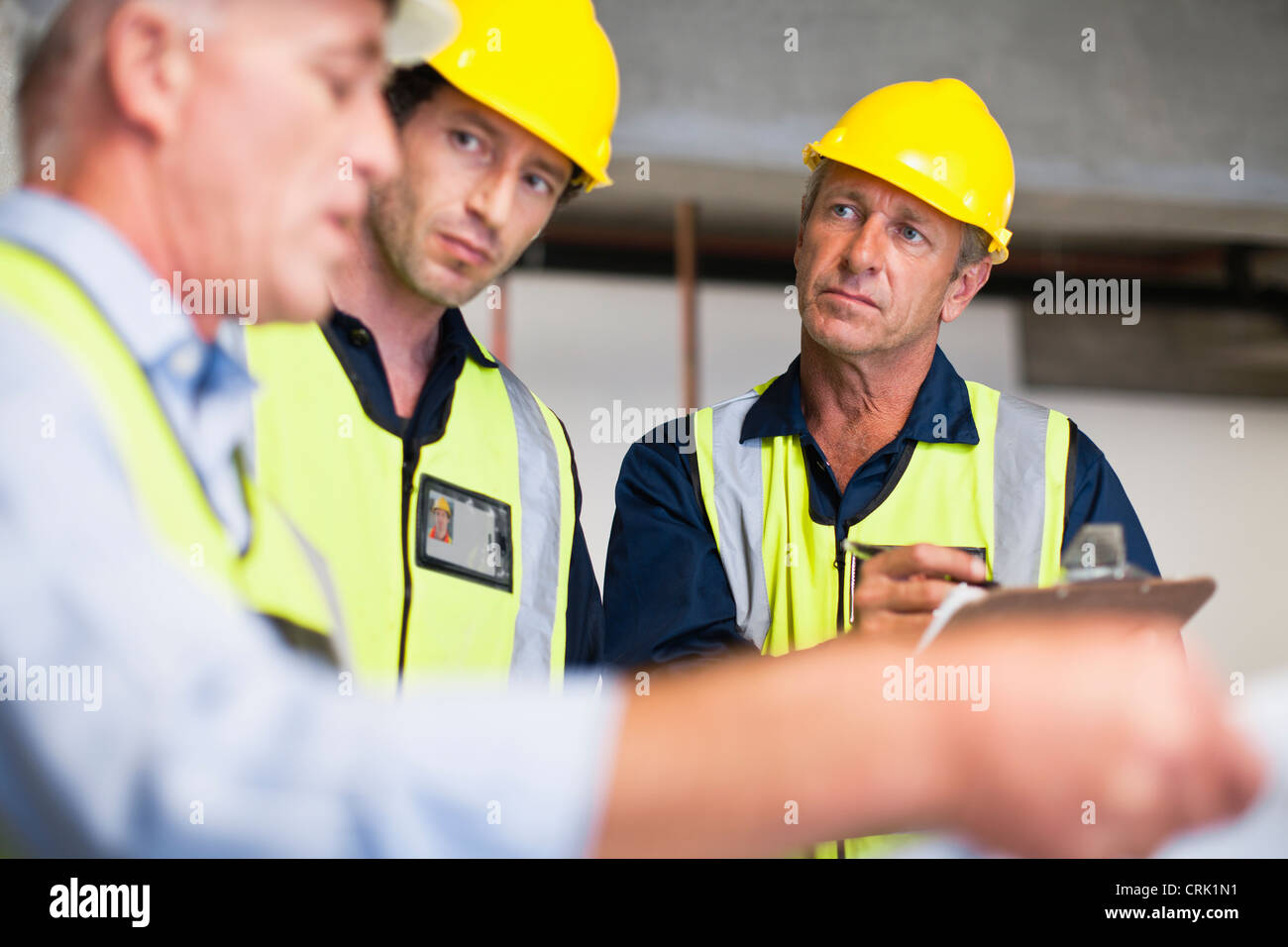 Workers reading blueprints on site Stock Photo - Alamy