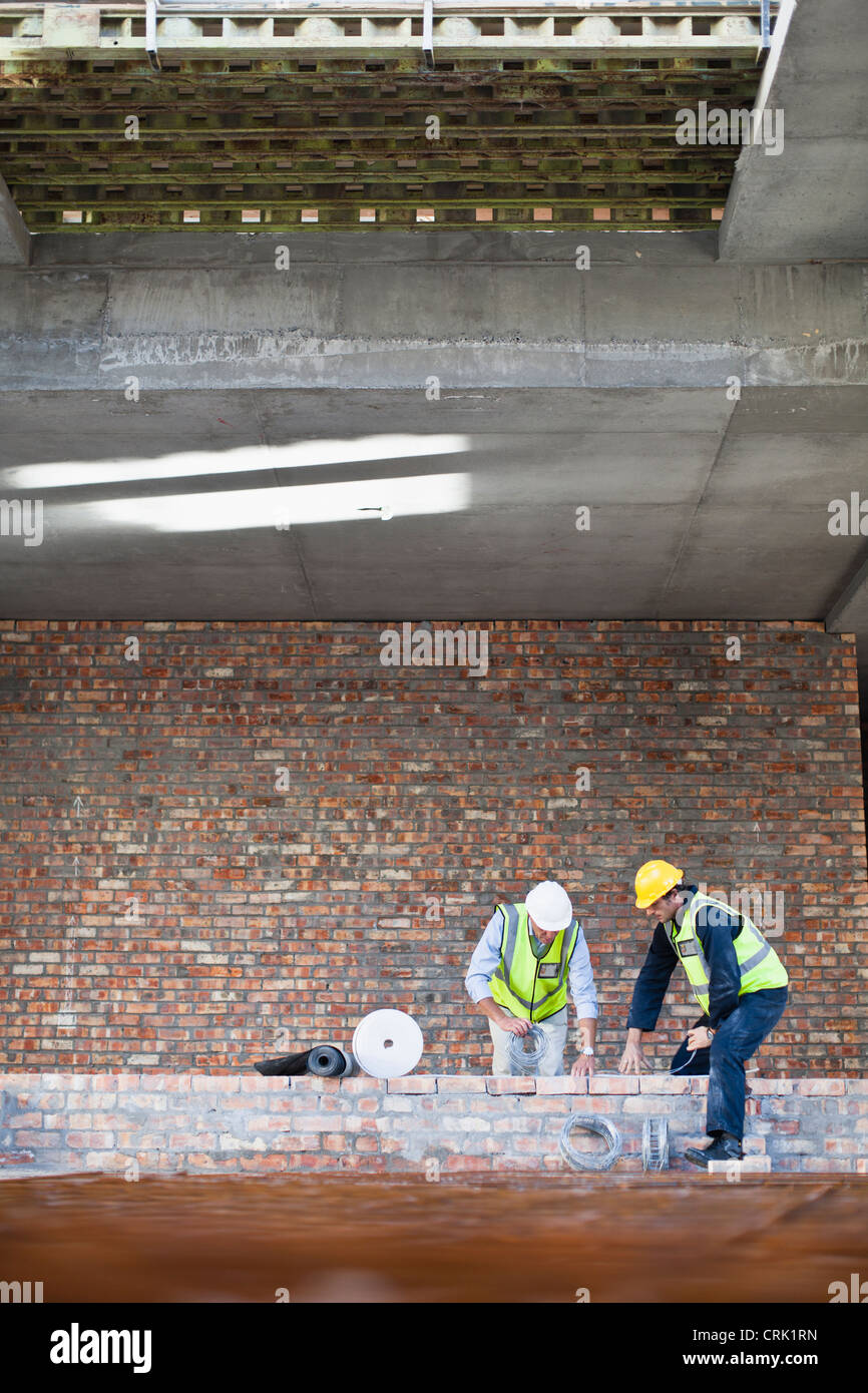 Workers laying brick on site Stock Photo - Alamy